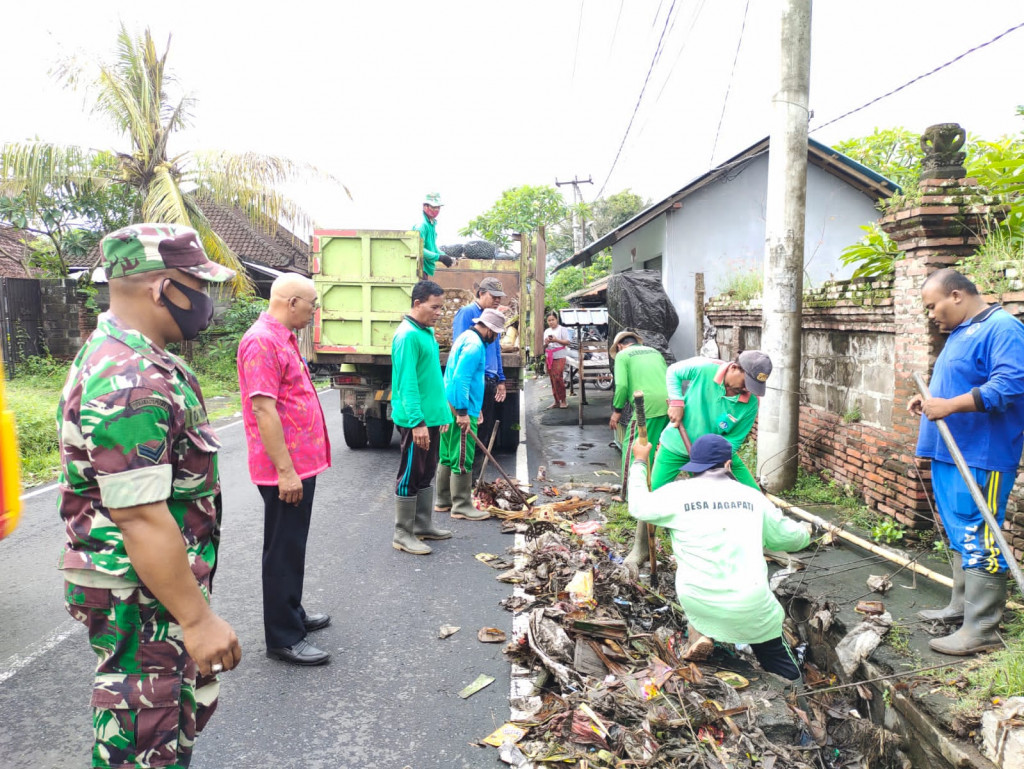 Tim kebersihan Desa Jagapati membersihkan sampah yang menyumbat di ...